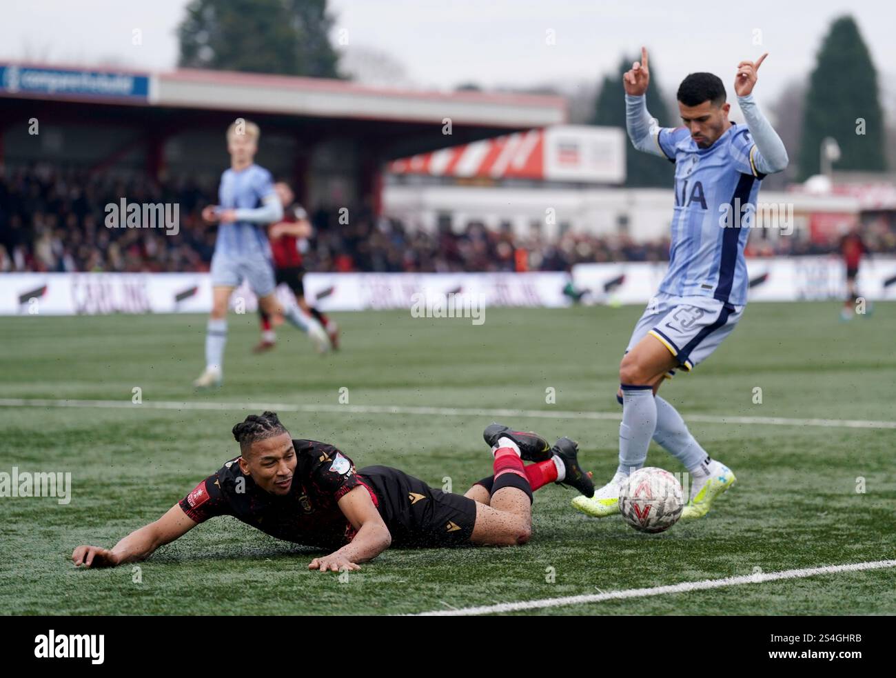 Tamworth's Kai Williams (left) goes to ground under a challenge from ...