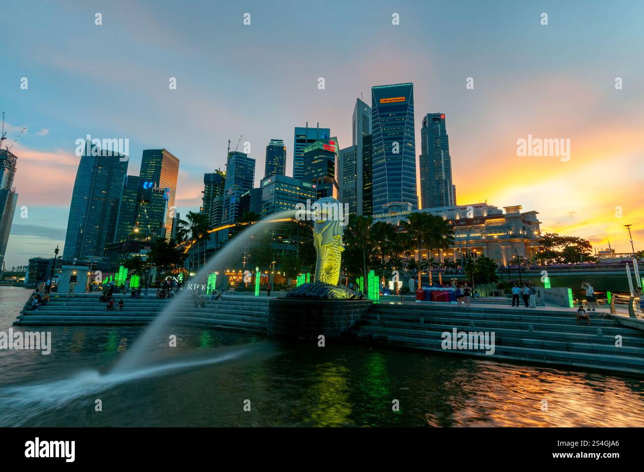Dusk over the financial district and the symbol of Singapore, the ...