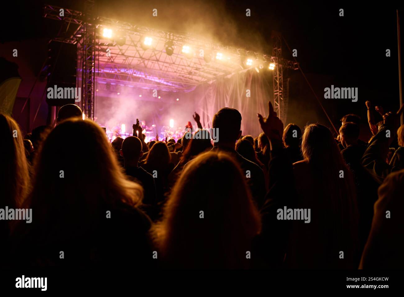 Vibrant live concert scene with band performing on stage under bright ...