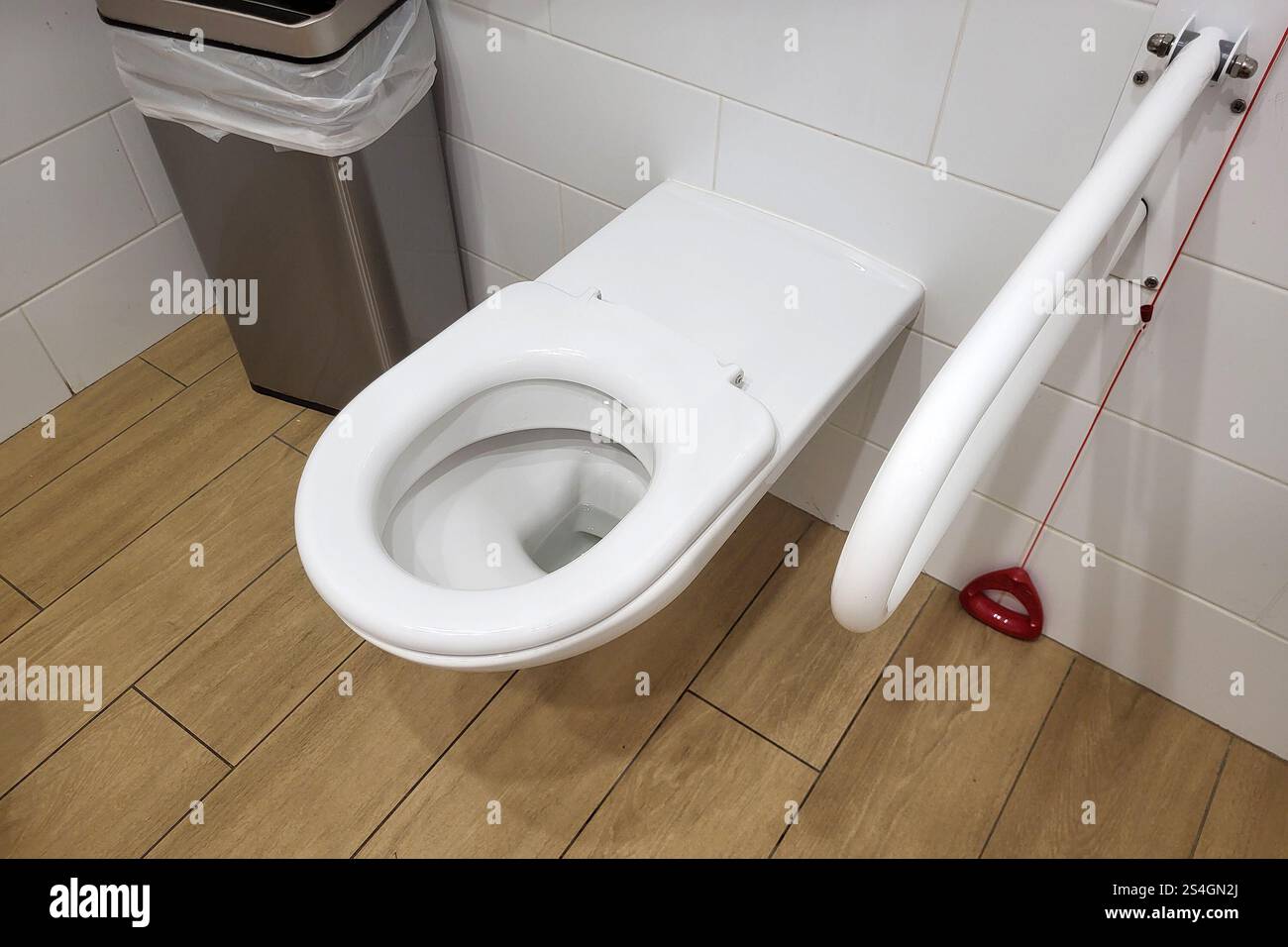 Accessible public restroom with wall-mounted toilet, safety grab bar ...