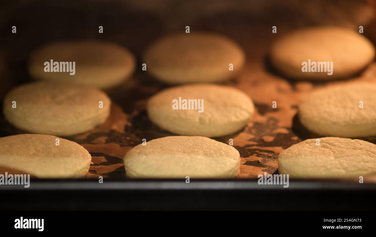 Baking round cookies on parchment paper inside oven. Close-up view of ...