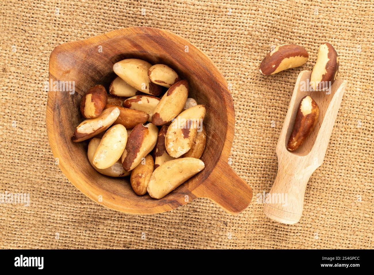 Brazil nuts without shells with wooden cup on jute cloth, close-up, top ...