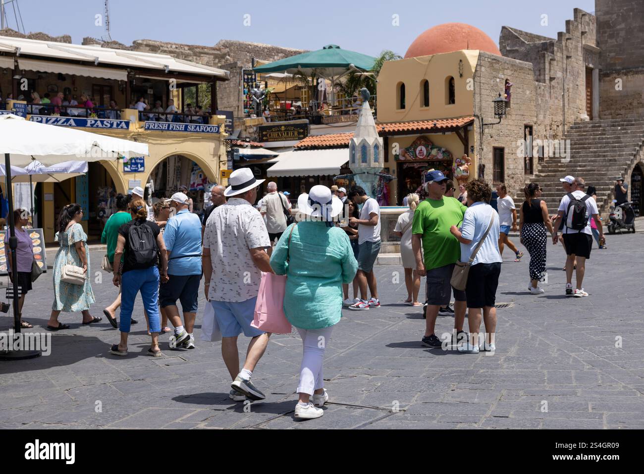 Tourists visit Rhodes Town, main town on Rhodes Island, medieval ...