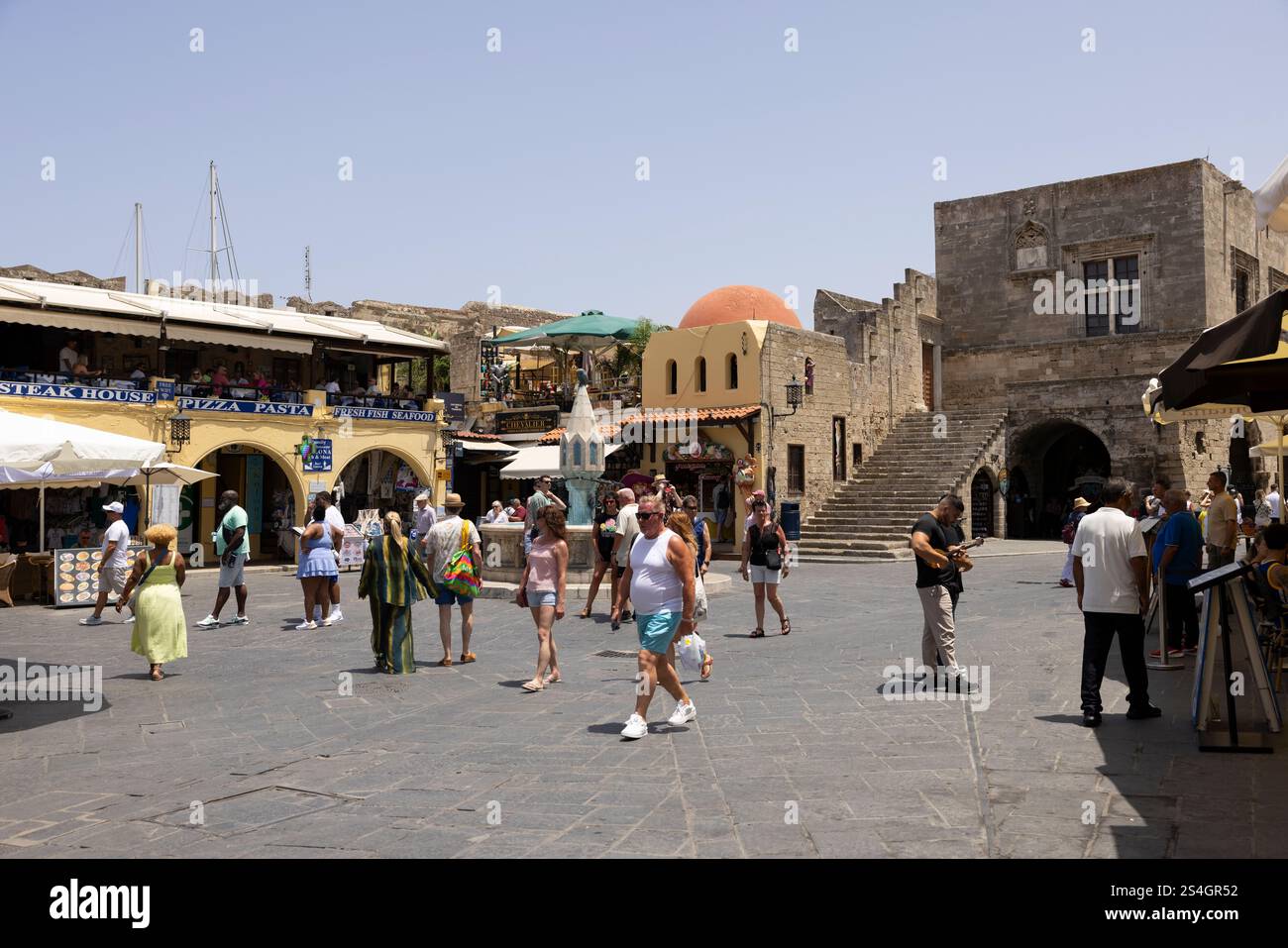 Tourists visit Rhodes Town, main town on Rhodes Island, medieval ...