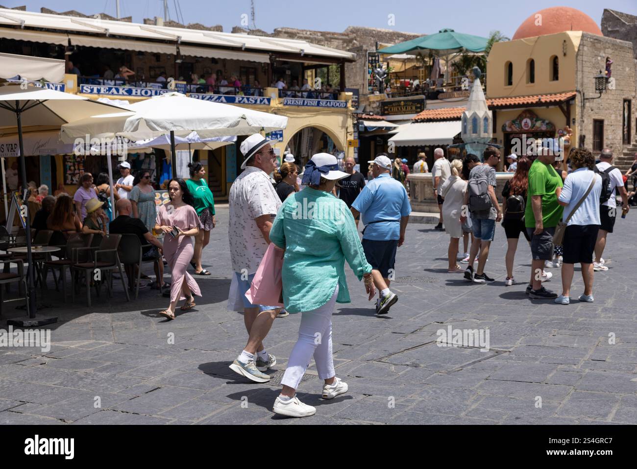 Tourists visit Rhodes Town, main town on Rhodes Island, medieval ...