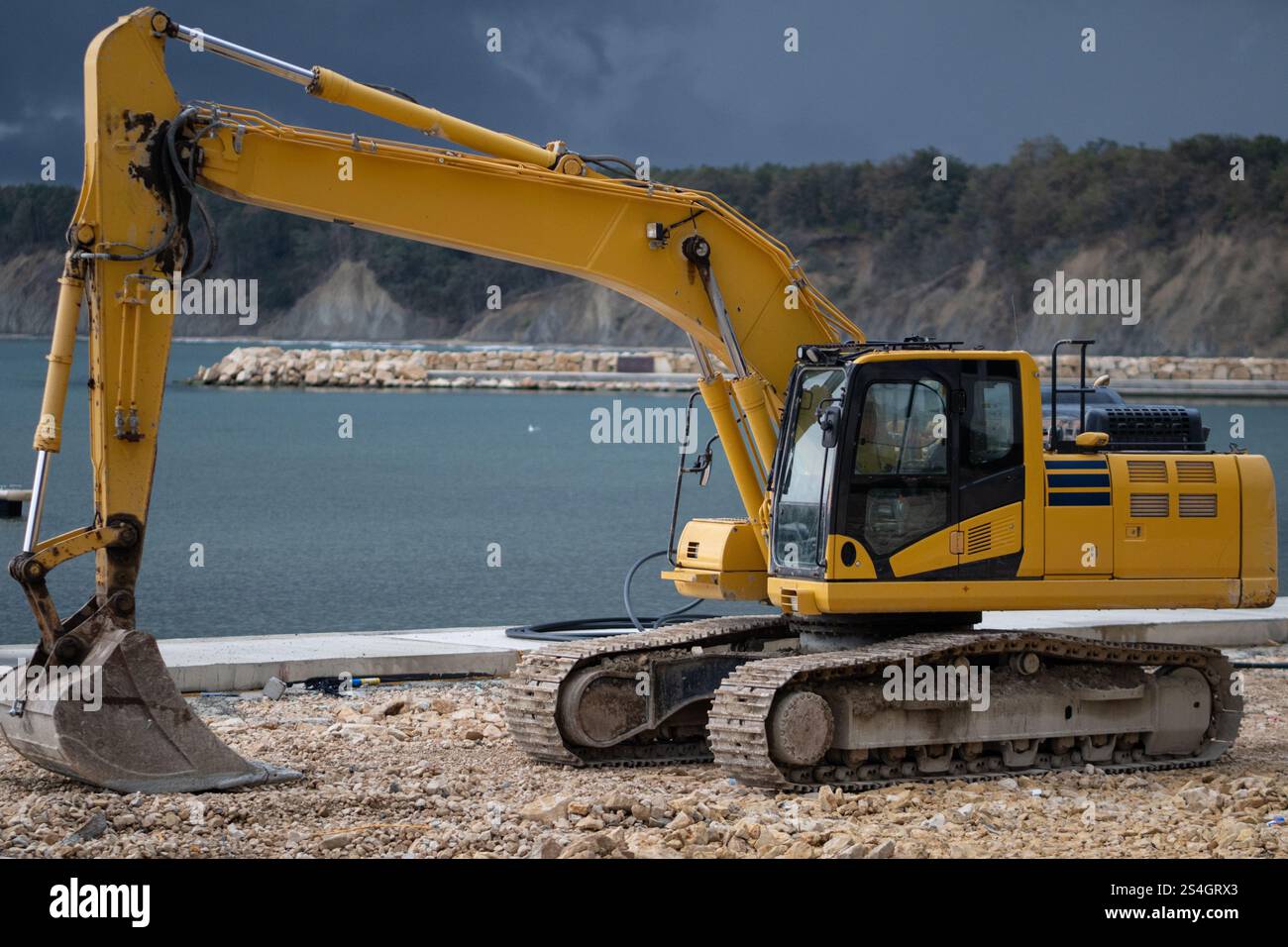 Yellow Excavator by the Sea Stock Photo - Alamy