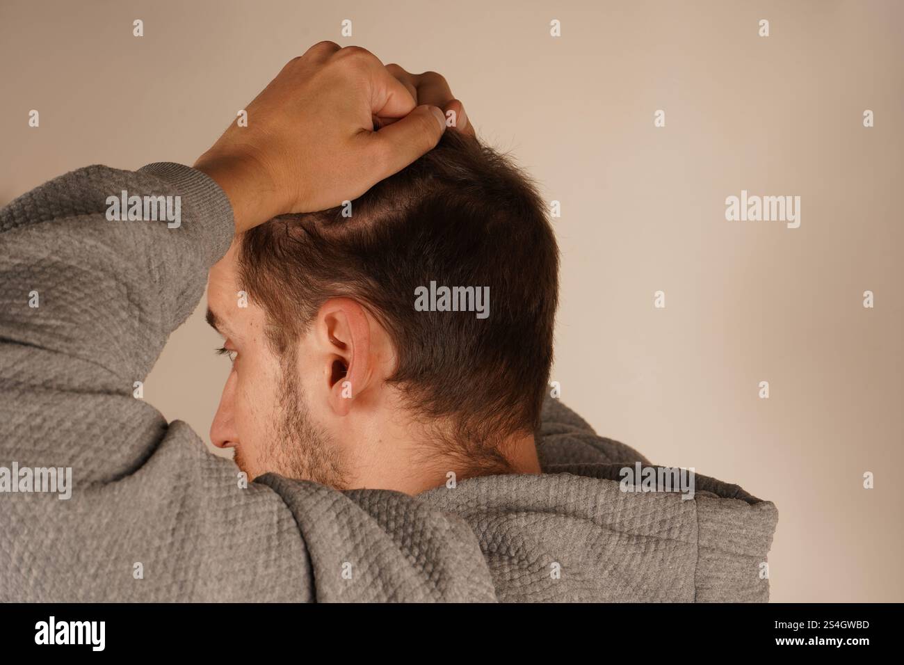 With both hands placed firmly on his head, the man shows signs of ...
