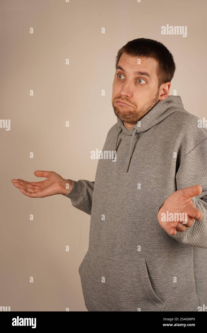 With hands extended outward, a man shrugs, appearing confused. The open ...