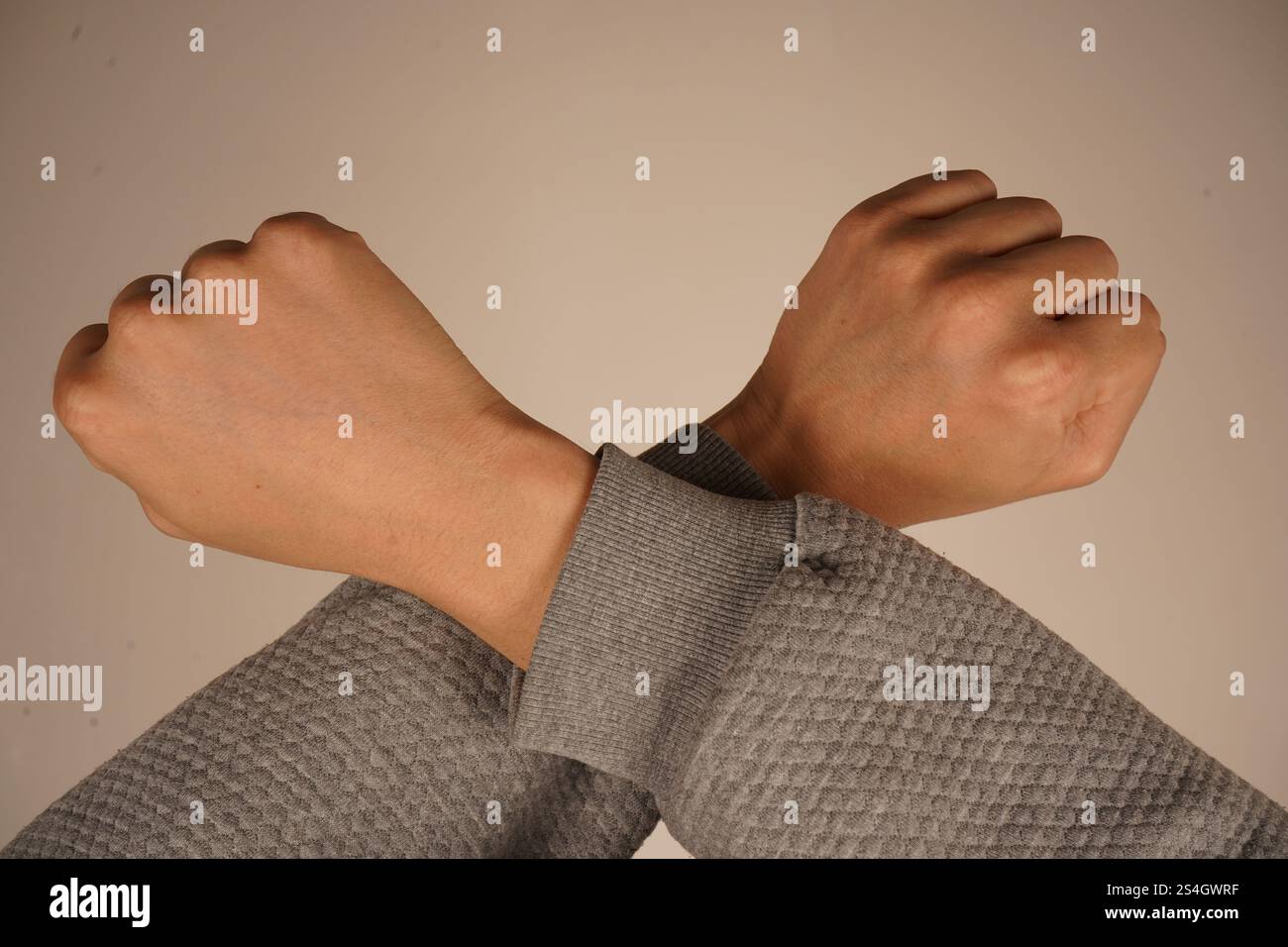 The crossed arms are clenched into fists. This posture radiates ...