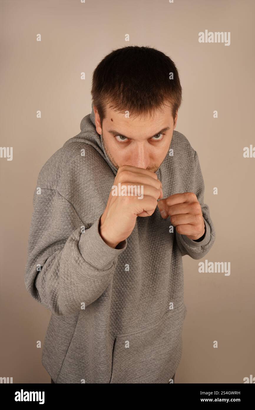 The mood is dynamic and intense. Wearing a sports hoodie, the man ...