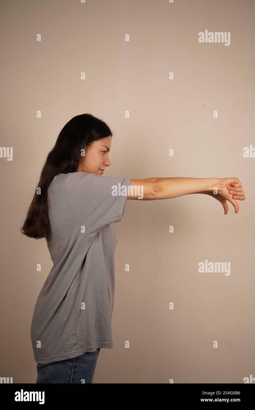 Serious woman showing double thumbs down gesture, expressing ...