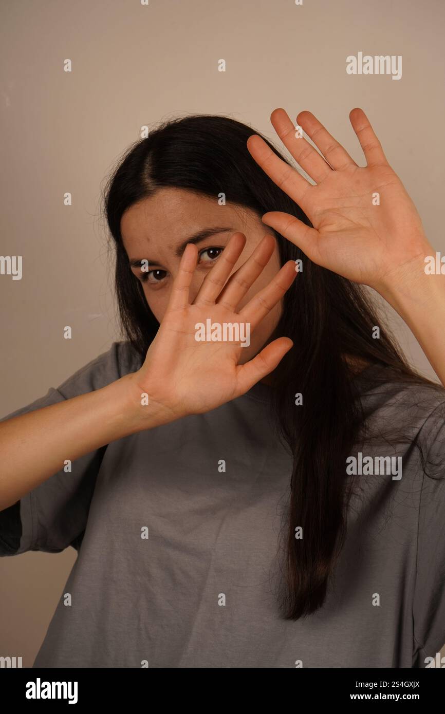 It highlights the theme of domestic violence. A woman holds both hands ...