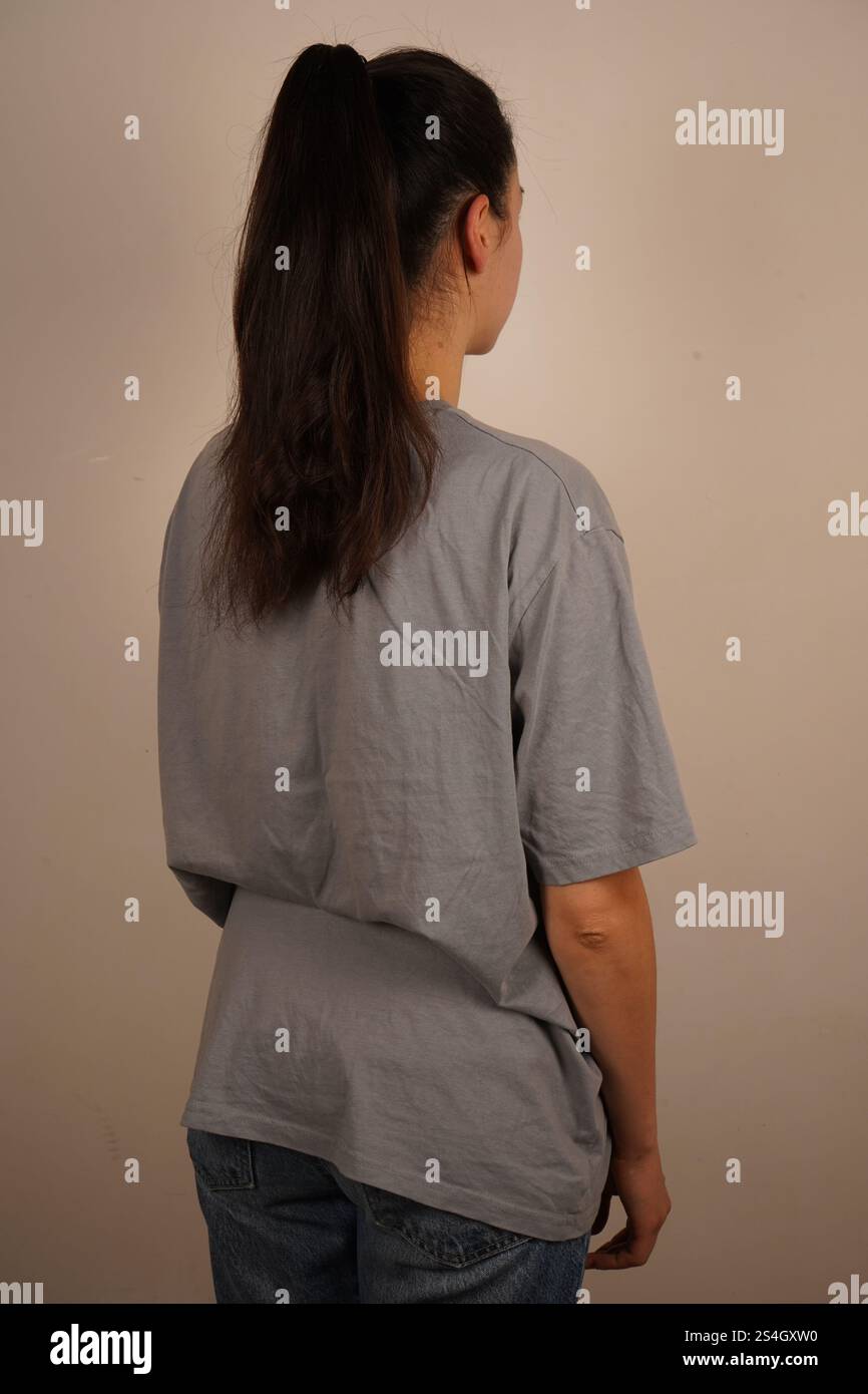 A rear view of a brunette woman with her dark hair styled into a neat ...