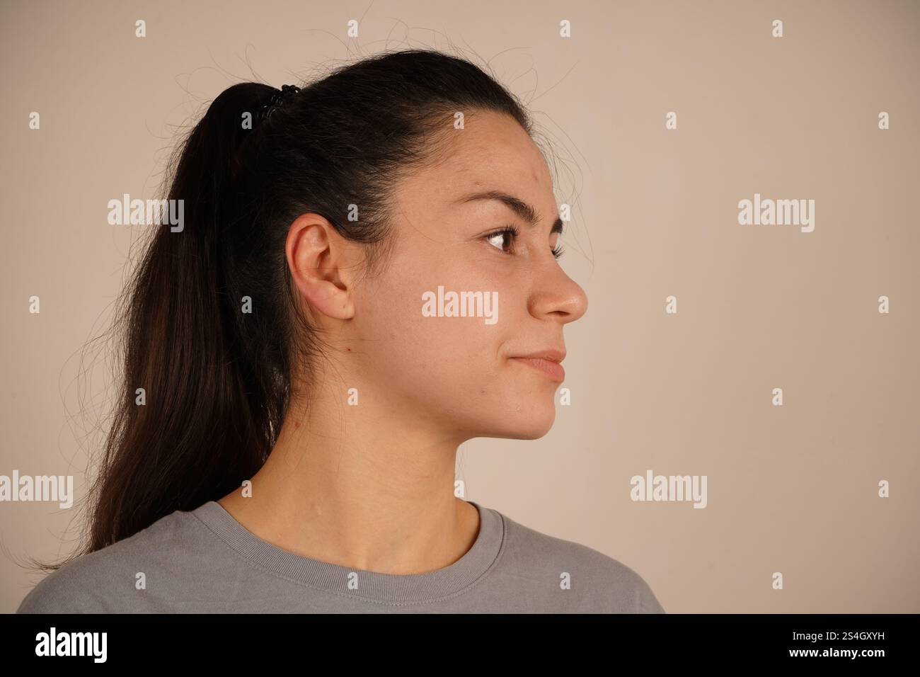 A detailed side view of a girl reveals her long, gathered hair in a ...