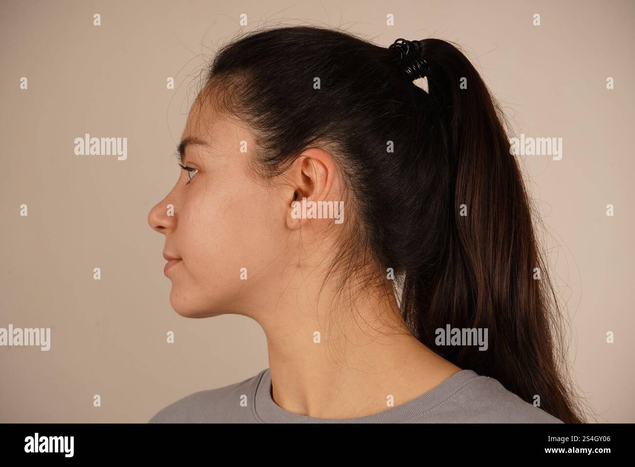 The graceful curve of her face complements her sleek hairstyle. The ...