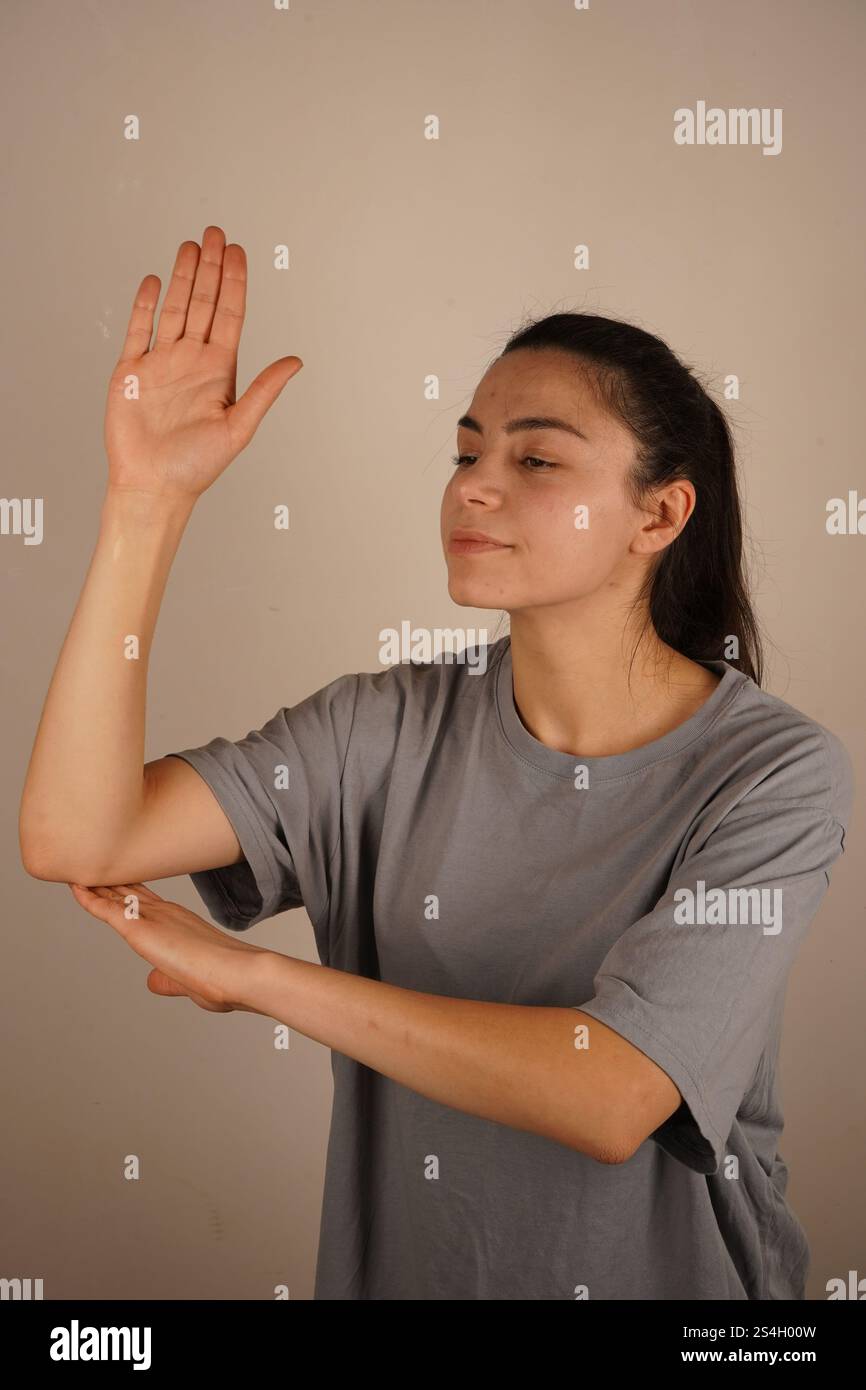 A student raises a hand with the elbow supported, signaling readiness ...