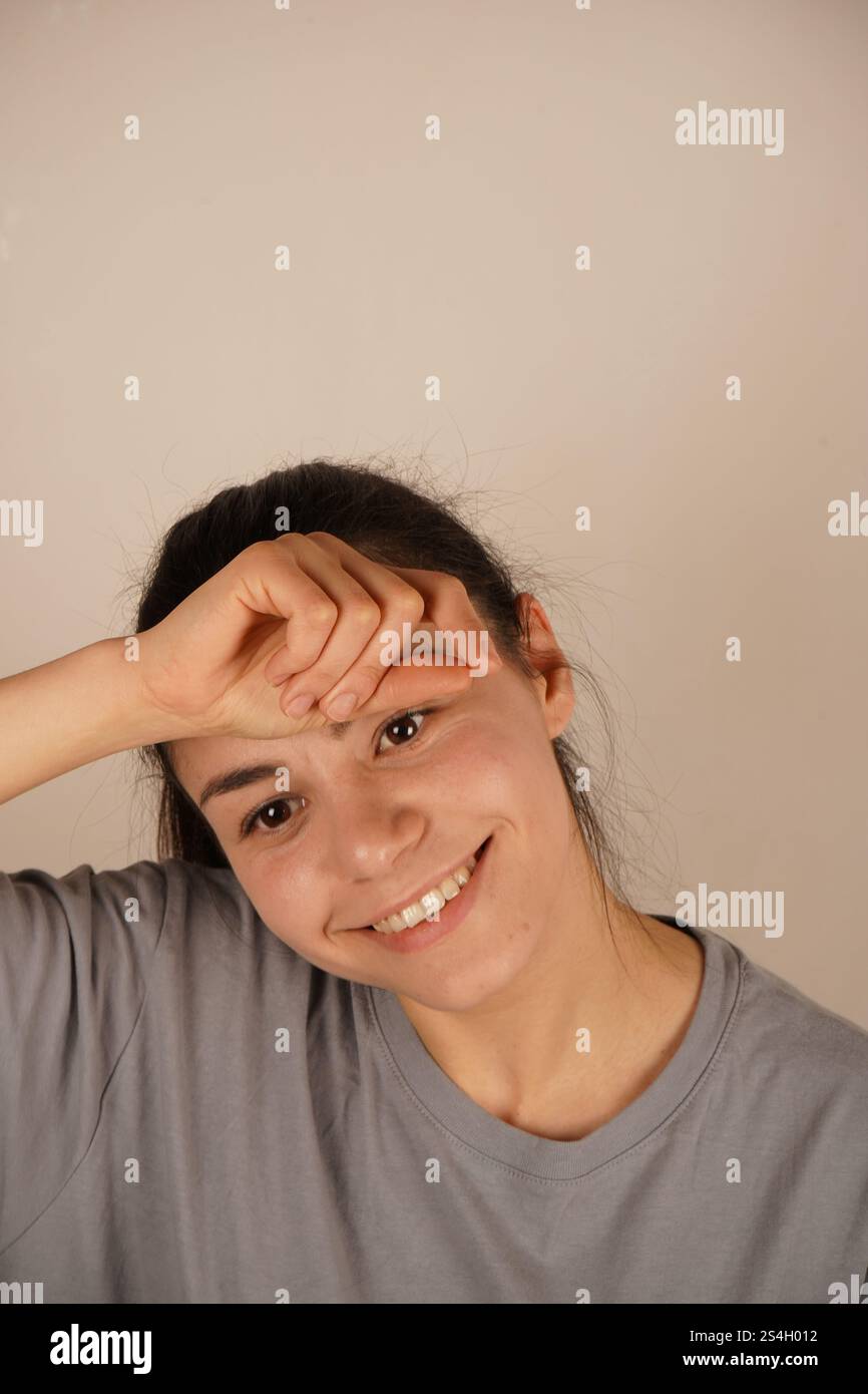 A woman holds her fist to her forehead. This gesture emphasizes ...