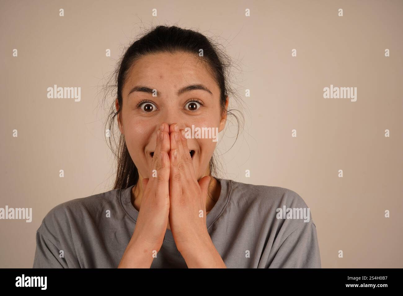 The woman laughs and presses her hands to her lips. Folded hands ...