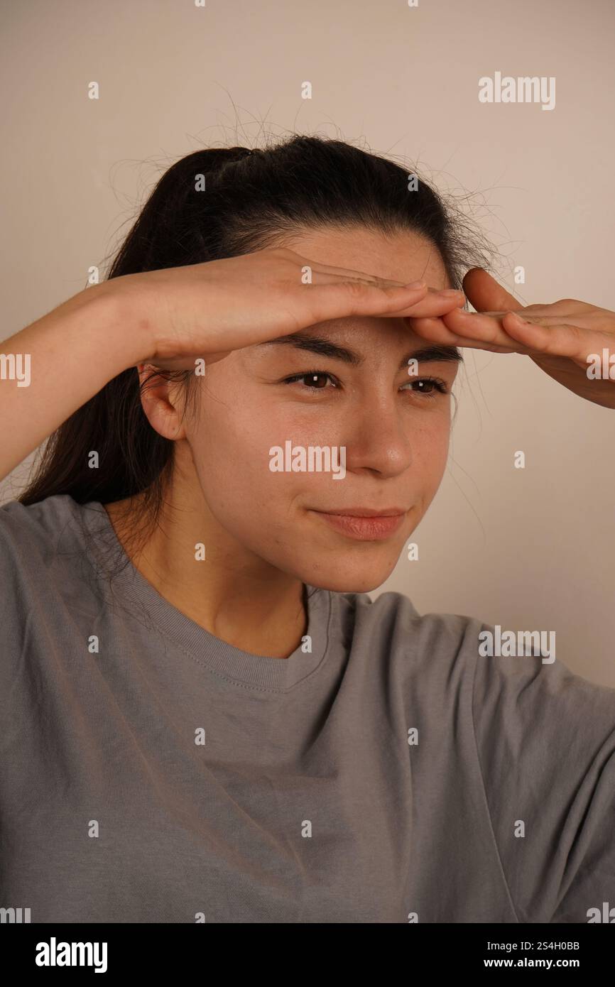 The back of the hand is gently pressed to the forehead, shielding it ...