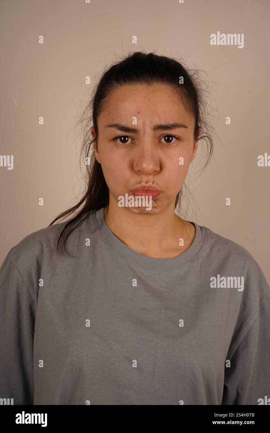 With wrinkled lips and raised eyebrows, she demonstrates shock or ...