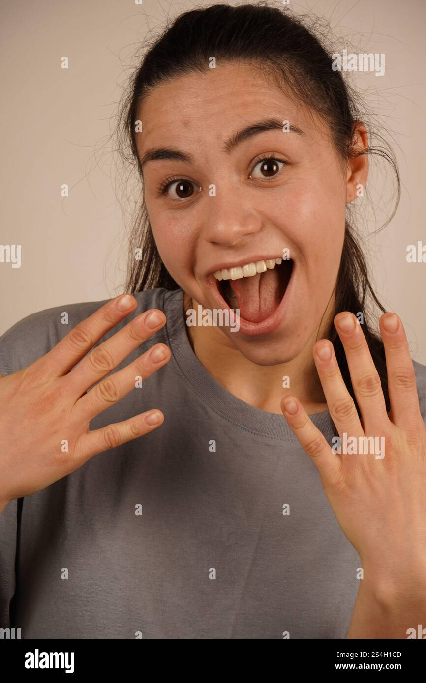 A woman raises her hands, showing the backs of her fingers. The joyful ...