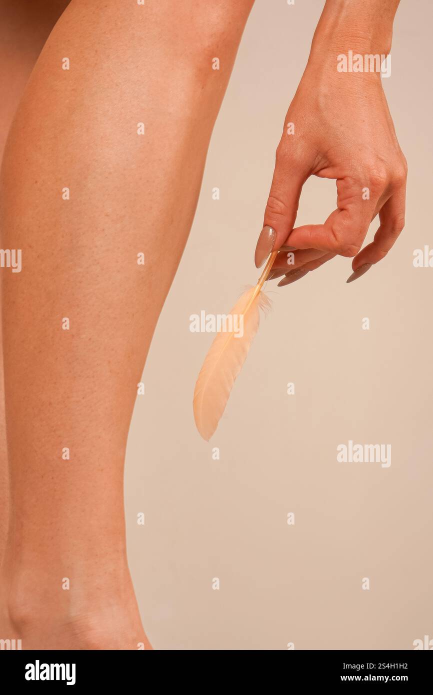 A close-up of smooth, shaved female legs being gently caressed with a ...