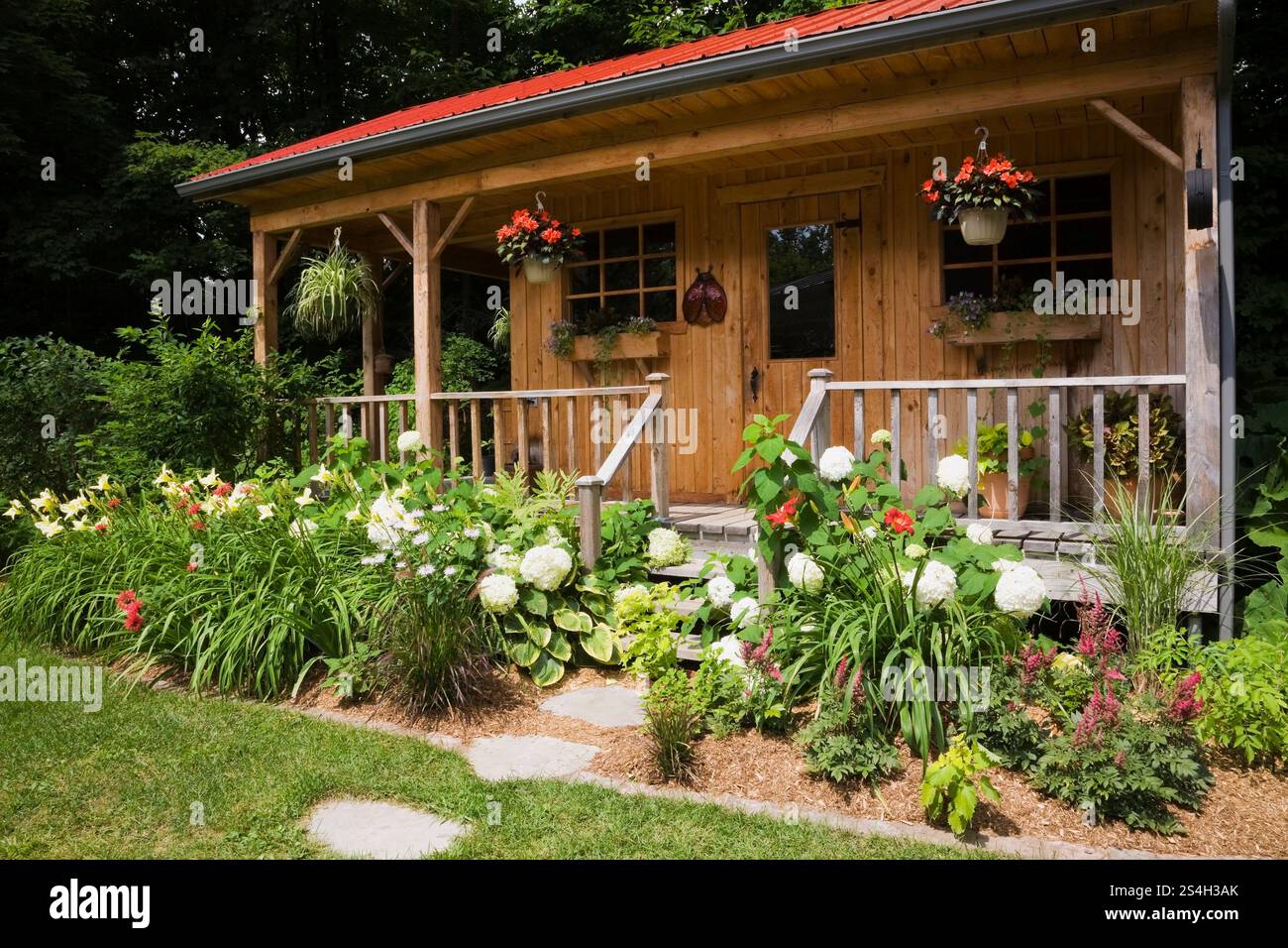 Red roof rustic wooden storage shed - workshop and mixed borders with ...