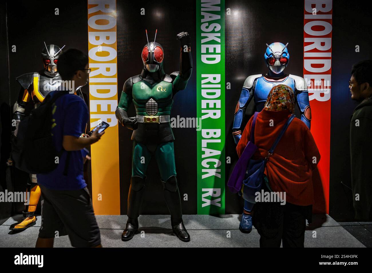 A fan of the Kamen Rider drama series takes a photo with the Kamen ...