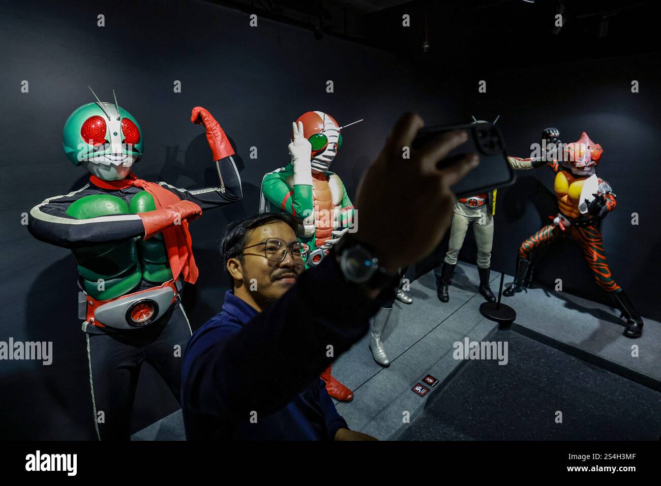 A fan of the Kamen Rider drama series takes a selfie with the Kamen ...