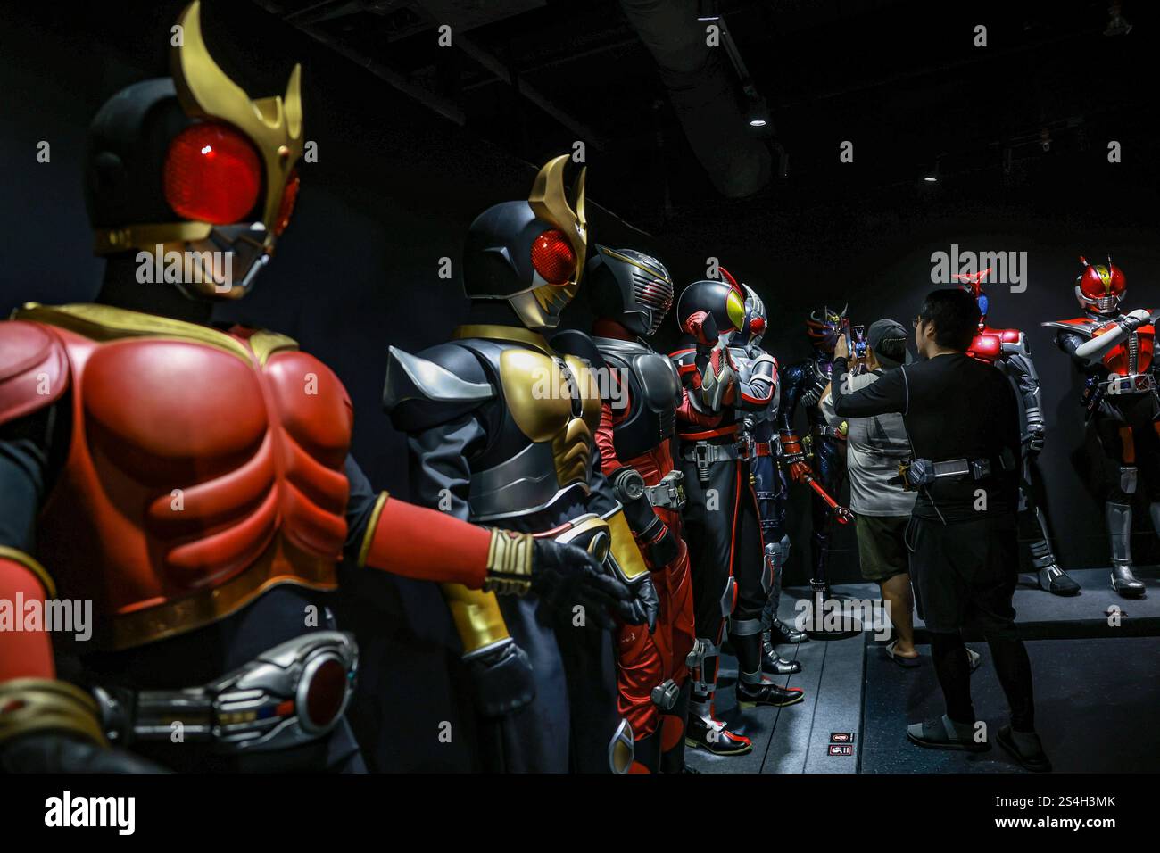 A fan of the Kamen Rider drama series takes a photo with the Kamen ...