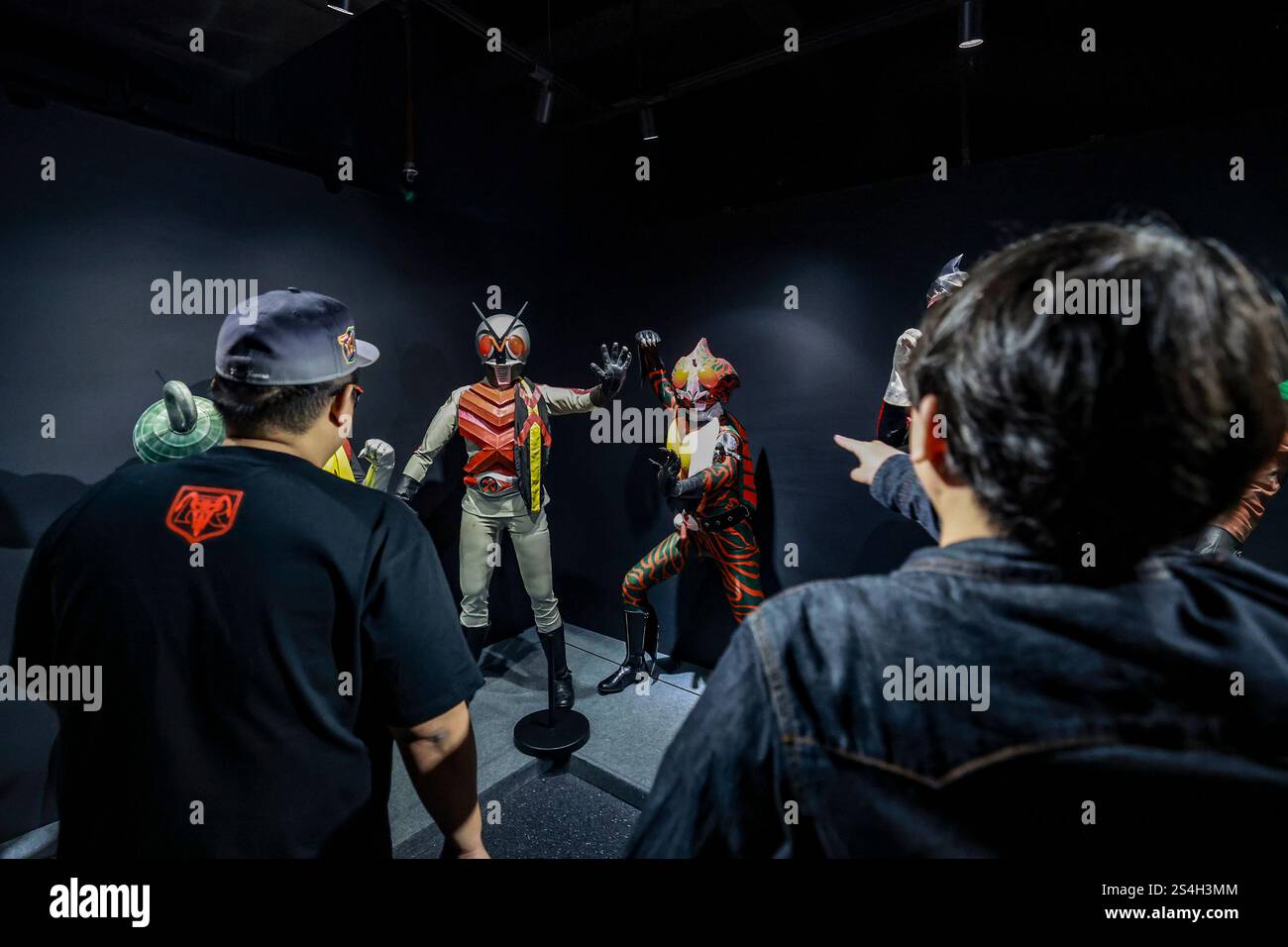A fan of the Kamen Rider drama series takes a photo with the Kamen ...