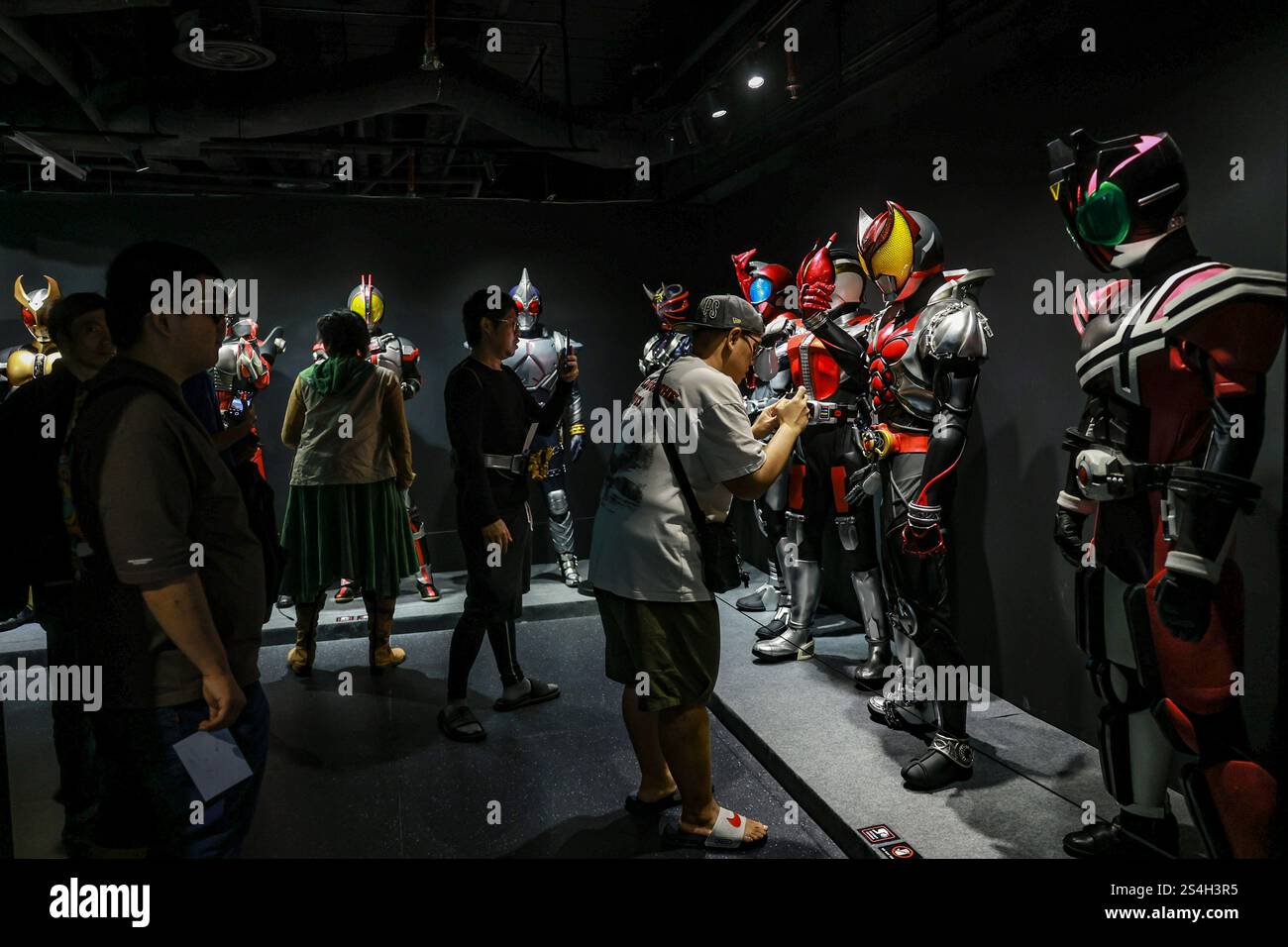 A fan of the Kamen Rider drama series takes a photo with the Kamen ...