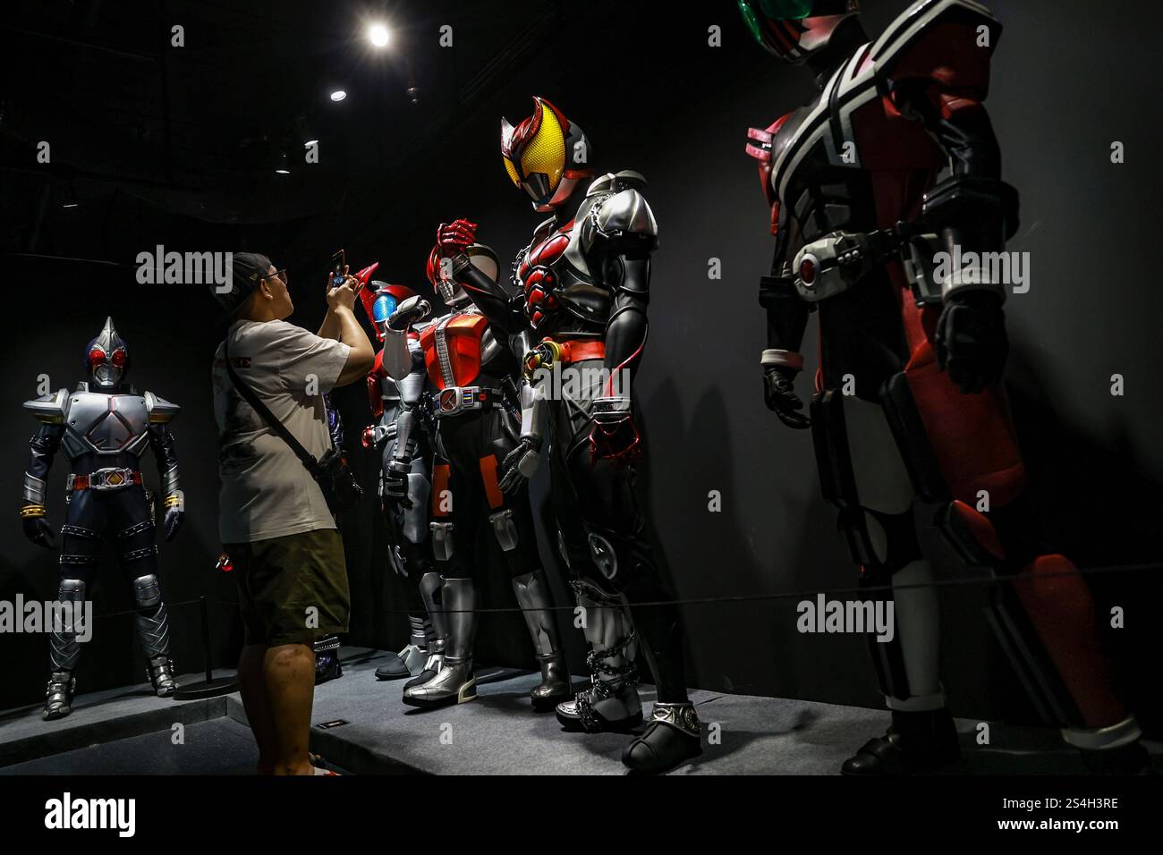 A fan of the Kamen Rider drama series takes a photo with the Kamen ...