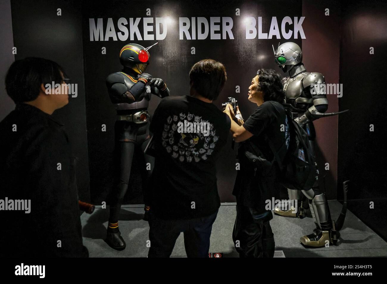 A fan of the Kamen Rider drama series takes a photo with the Kamen ...