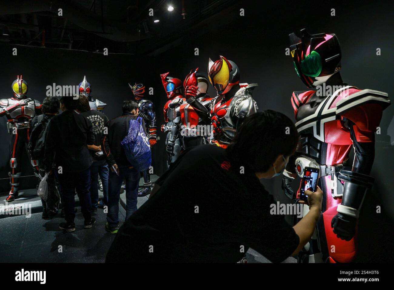A fan of the Kamen Rider drama series takes a photo with the Kamen ...