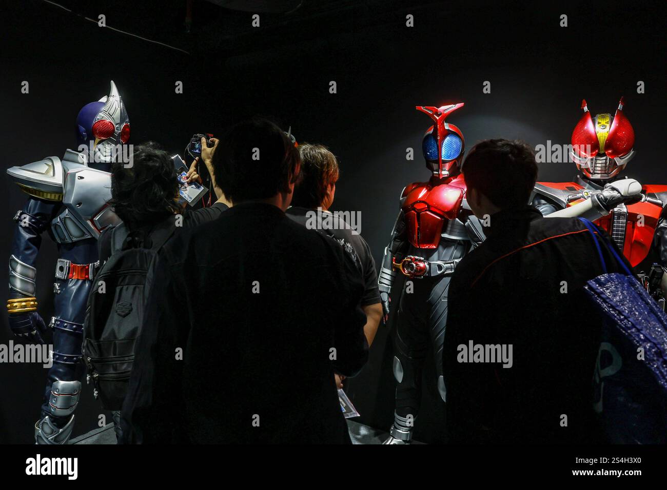 A fan of the Kamen Rider drama series takes a photo with the Kamen ...