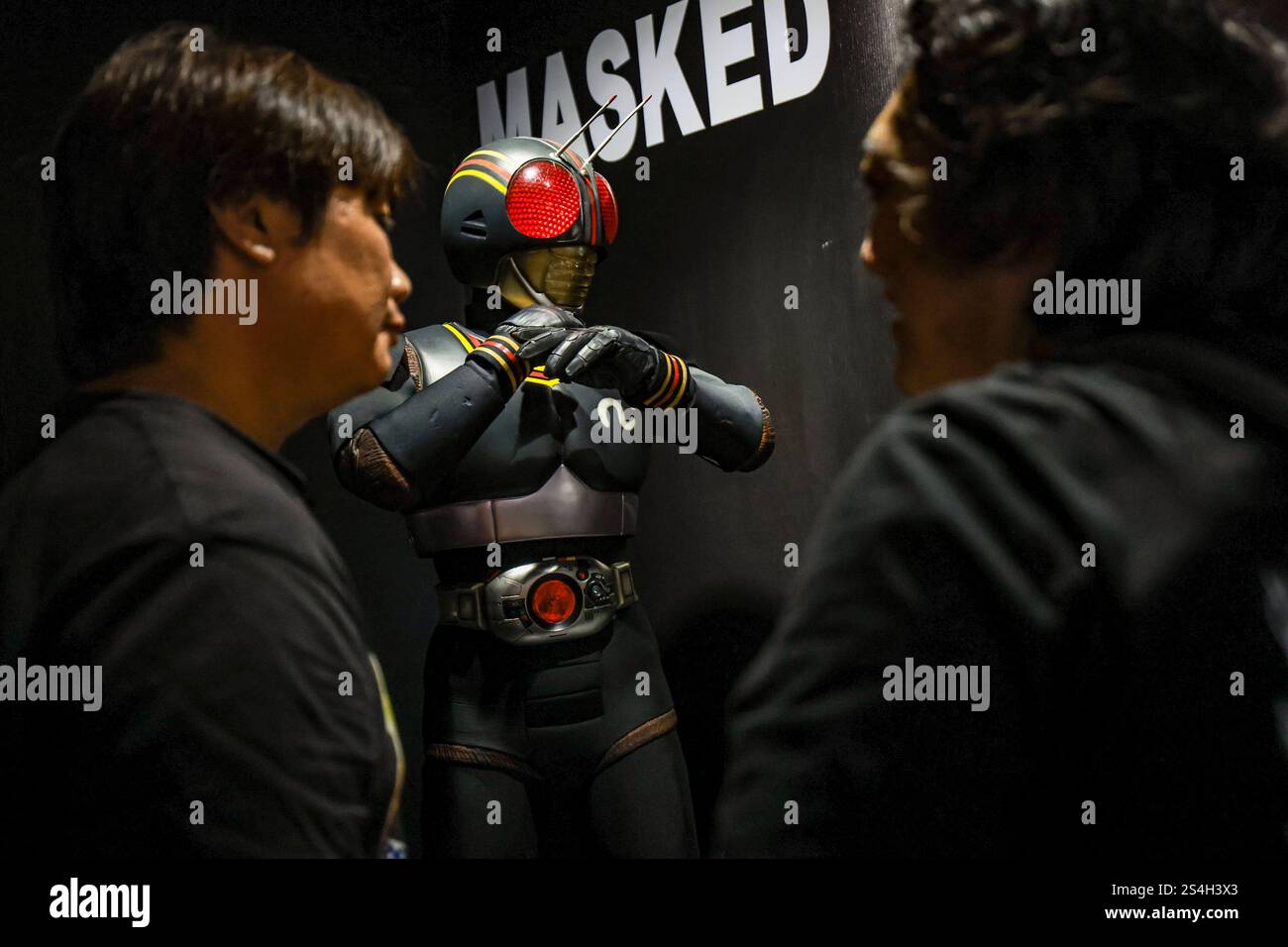 A fan of the Kamen Rider drama series takes a photo with the Kamen ...