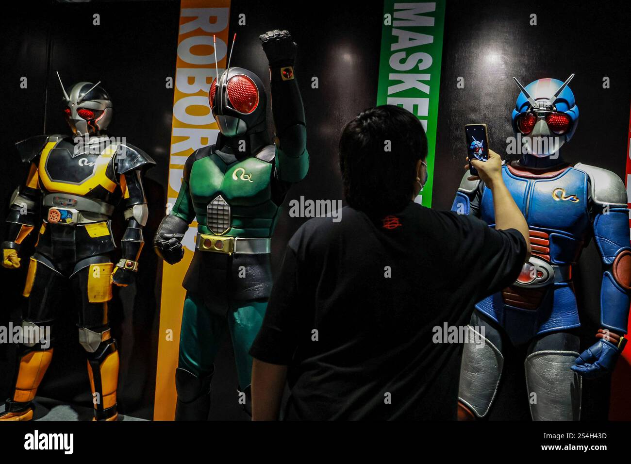 A fan of the Kamen Rider drama series takes a photo with the Kamen ...