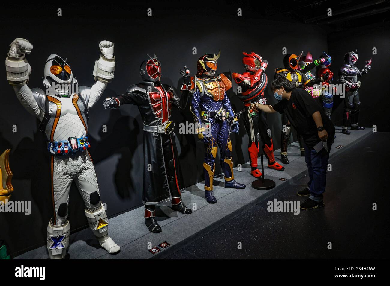 A fan of the Kamen Rider drama series takes a photo with the Kamen ...