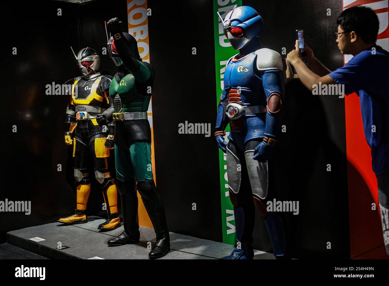 A fan of the Kamen Rider drama series takes a photo with the Kamen ...