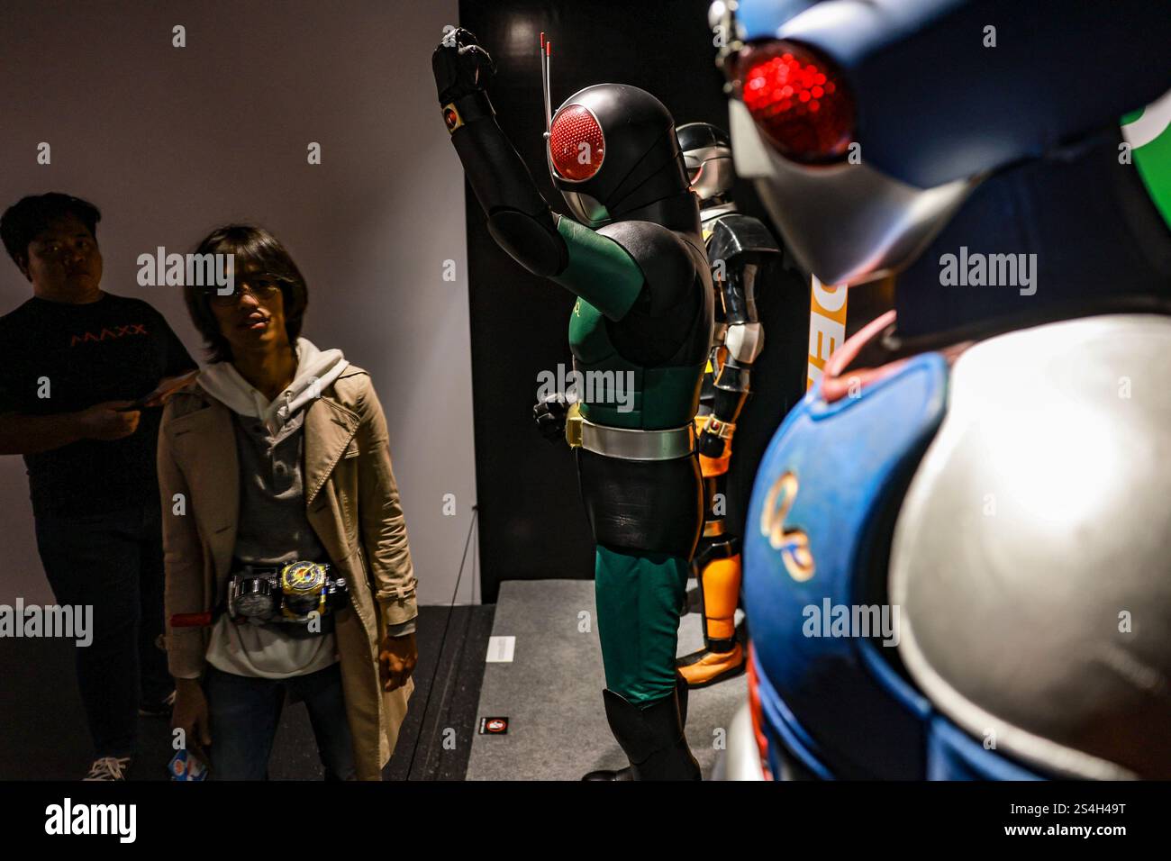 A fan of the Kamen Rider drama series takes a photo with the Kamen ...
