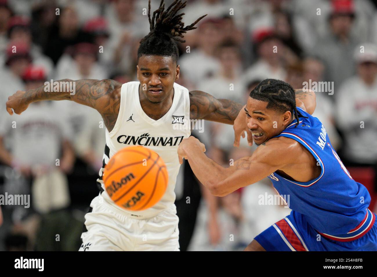 Kansas guard AJ Storr, right, chases a loose ball against Cincinnati ...