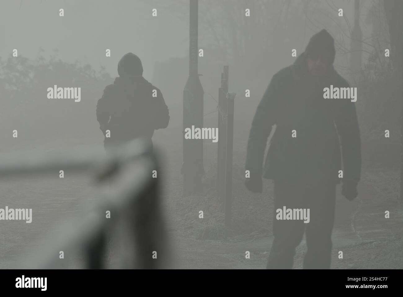 London, UK. 12th Jan 2025. UK Weather. Fog shrouds a jogger and walker ...