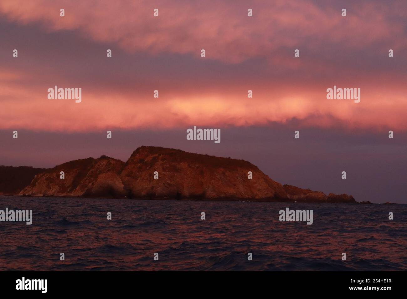 Mountains are seen through the sunset near the bay of Cacaluta, part of ...