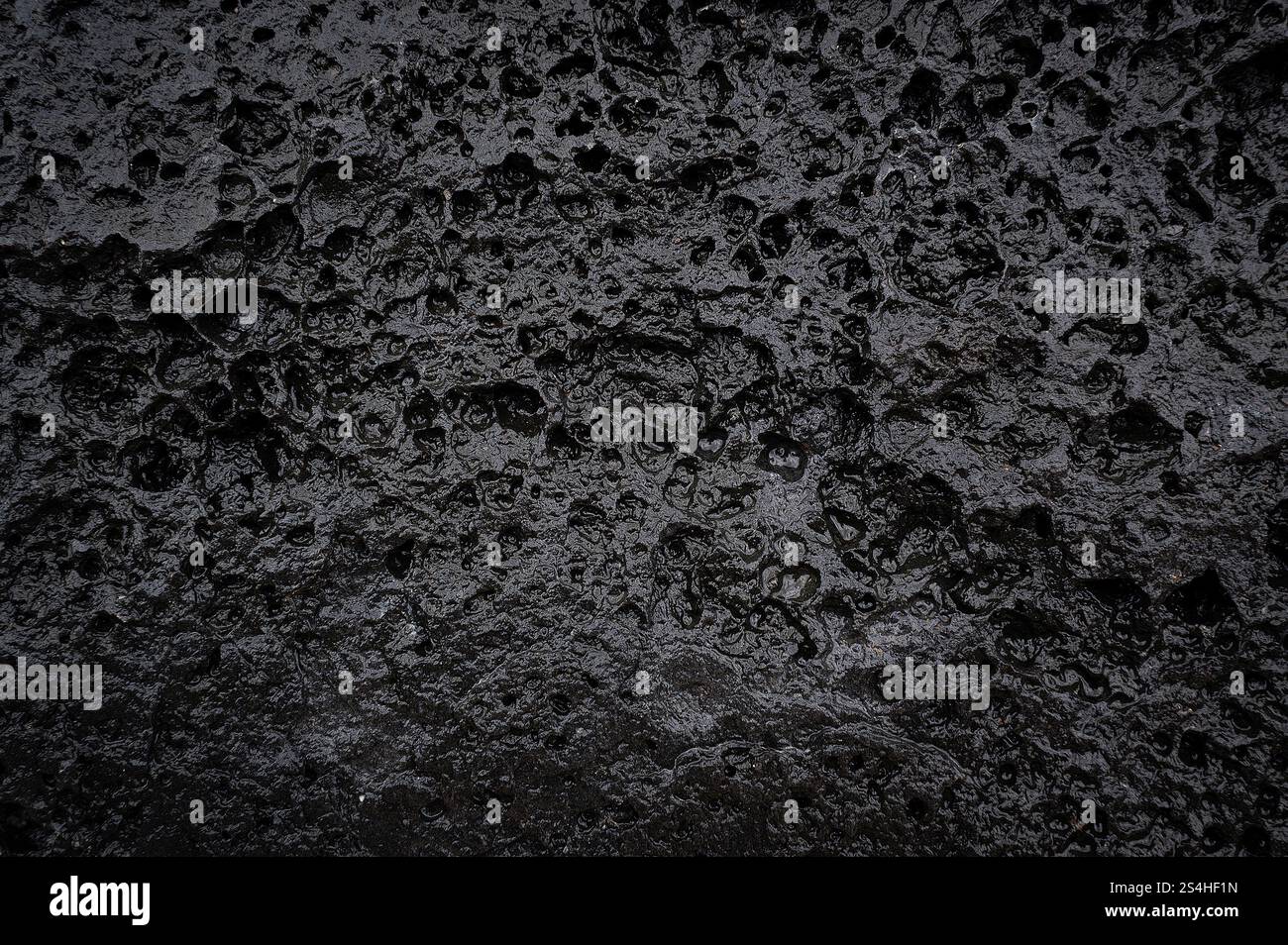 Black grey background lava stone with erosion holes caused by wind ...