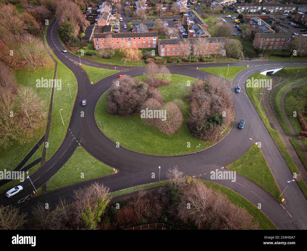 Aerial view of cars driving on a roundabout in a residential area ...