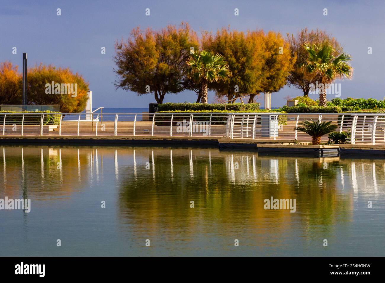 Scenic Waterfront Park with Trees and Reflective Water in Bright ...
