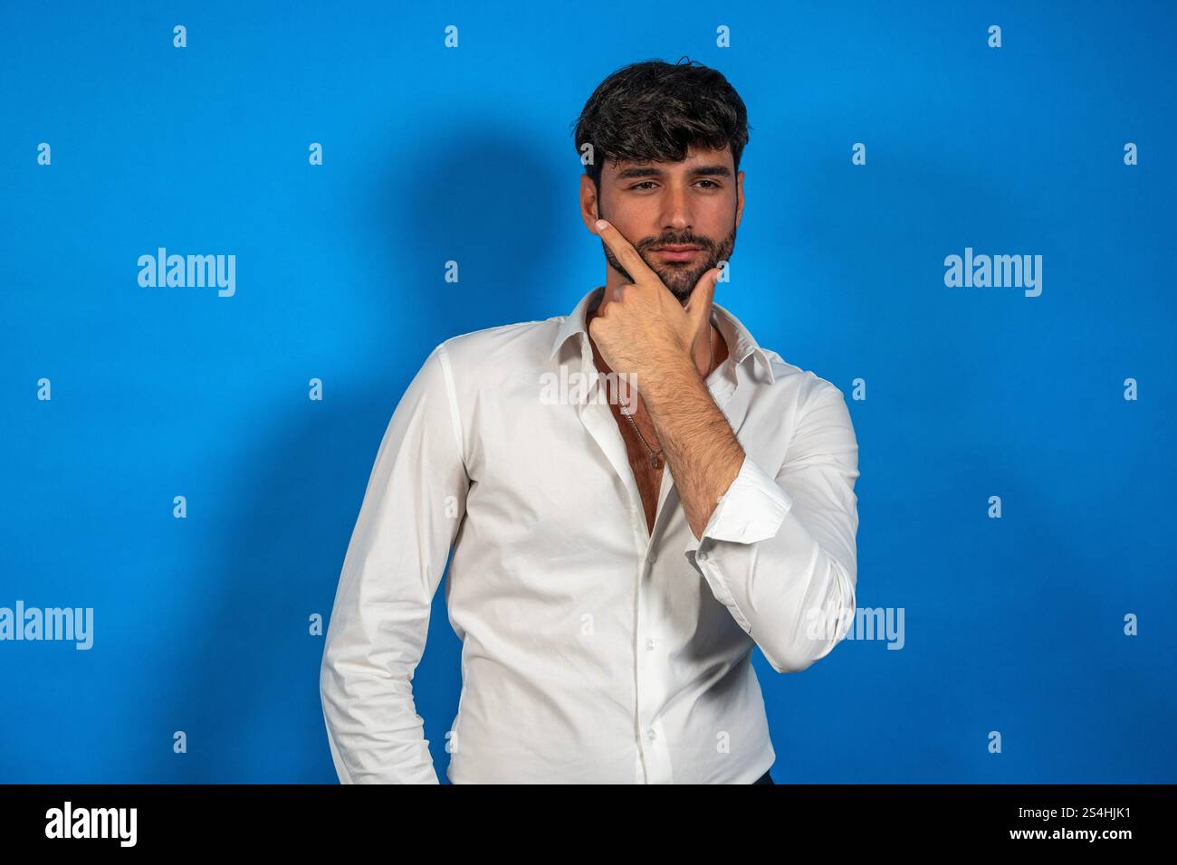 Thinking businessman touching his chin against splash on wall revealing ...