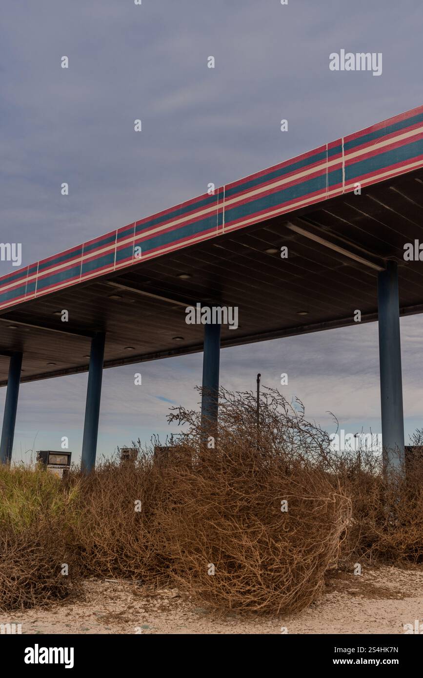 Tumbleweed in front of an abandoned gas station with a tall canopy ...