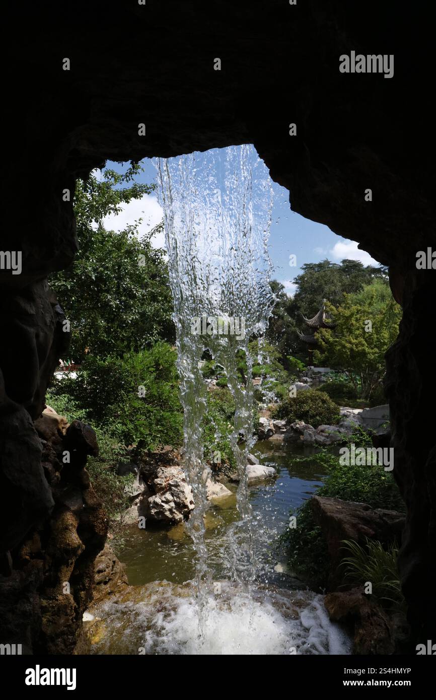 Standing behind a waterfall, looking through the water at a Chinese ...